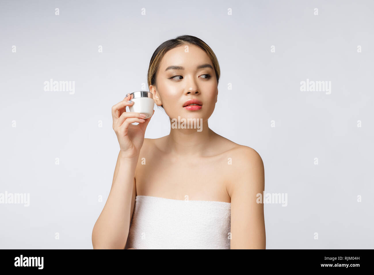Beautiful Asia woman presenting product isolated on white background ...