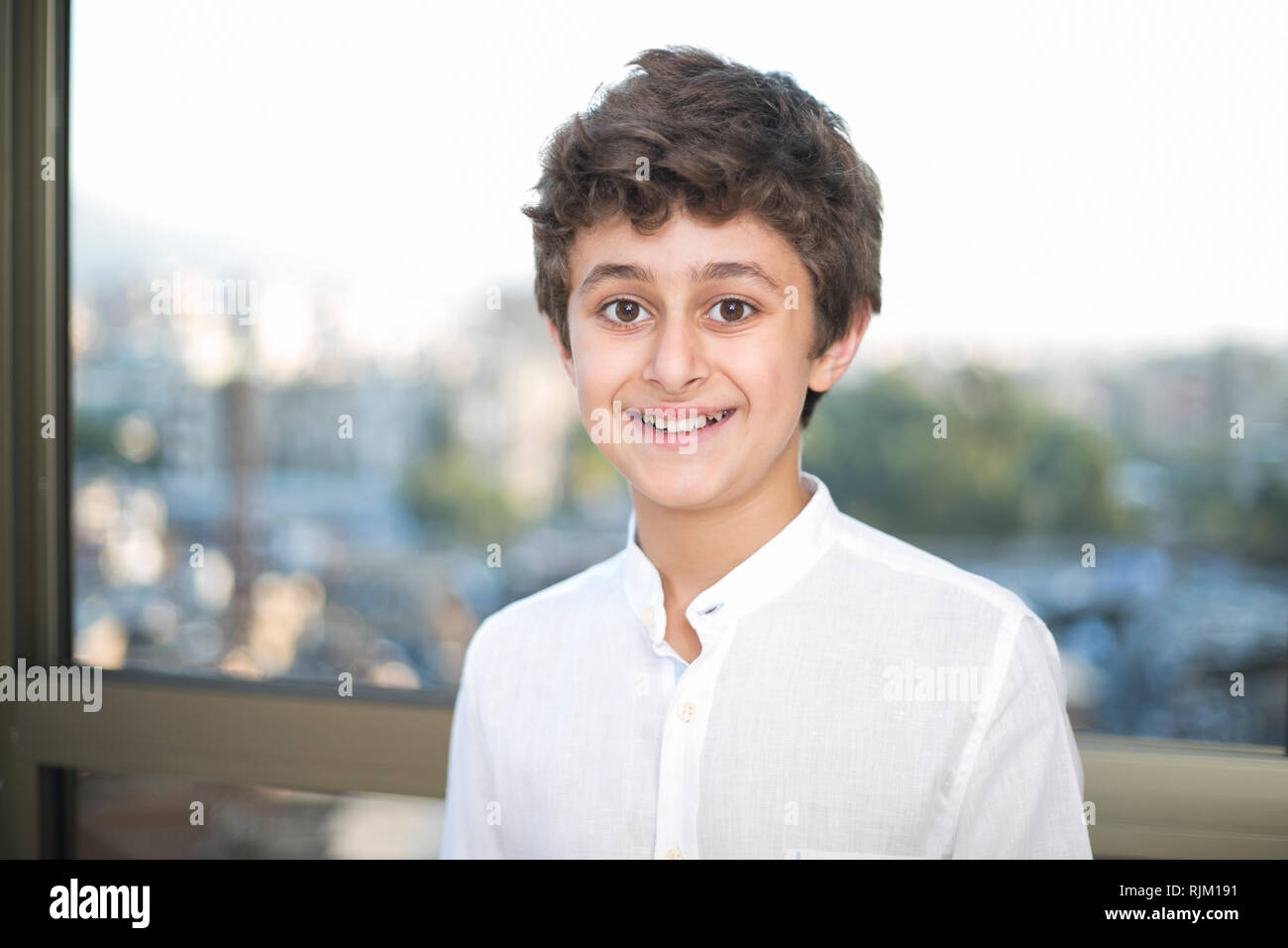 Happy boy smiling by the window Stock Photo - Alamy