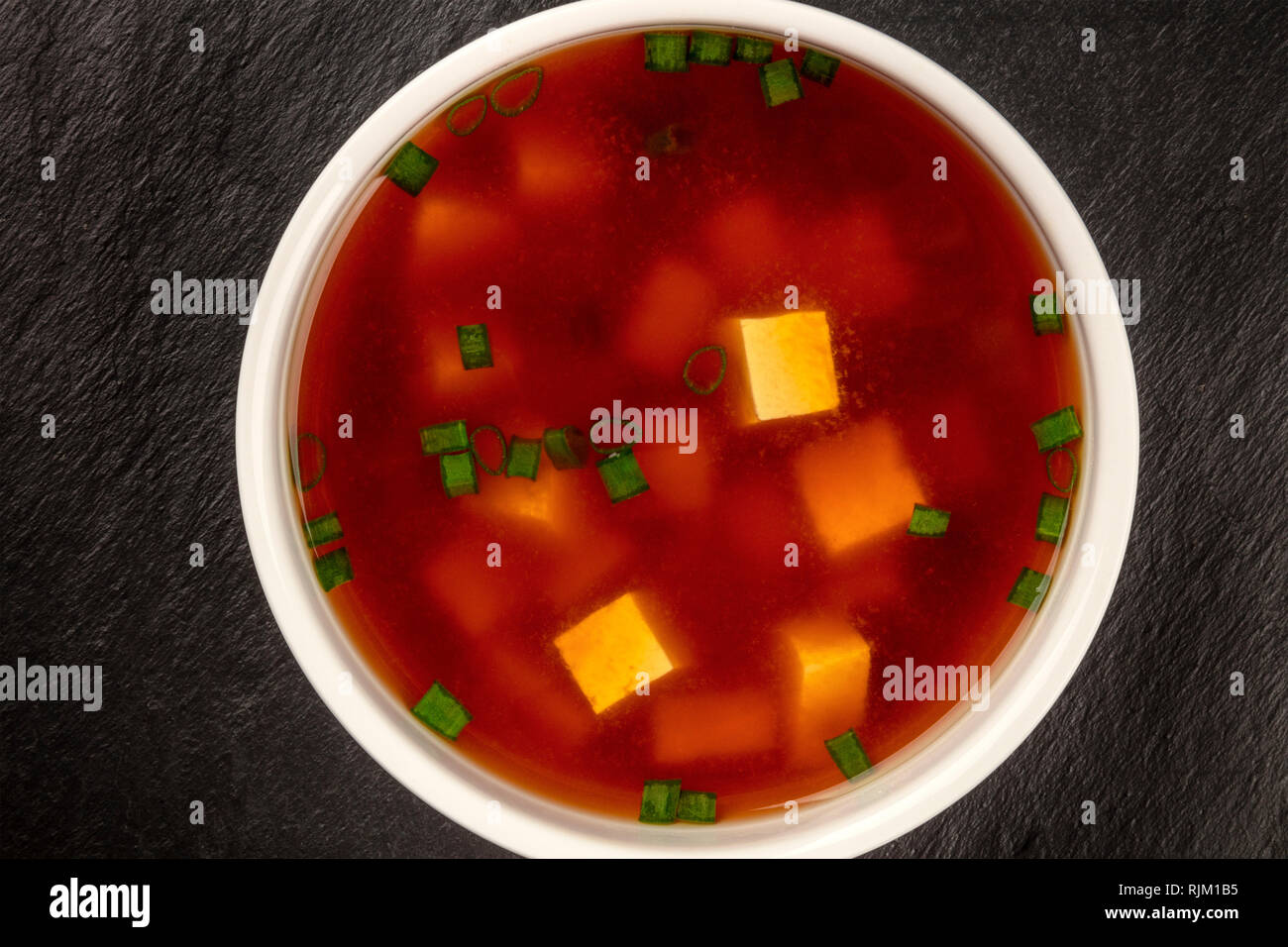 A closeup of miso shiru soup with tofu and scallions, shot from the top ...