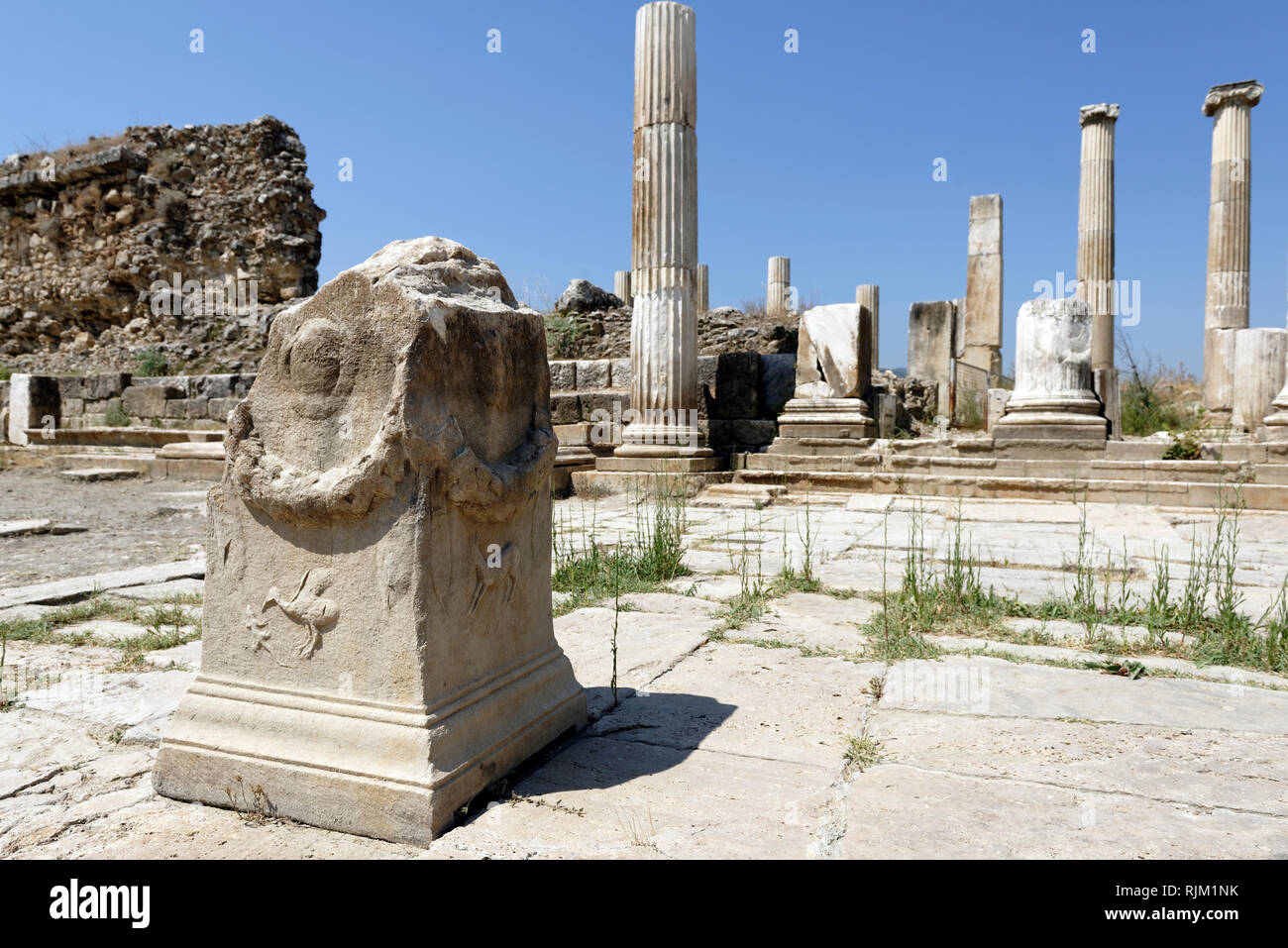 Statue pedestal with a bas relief, Agora propylon is in the background ...