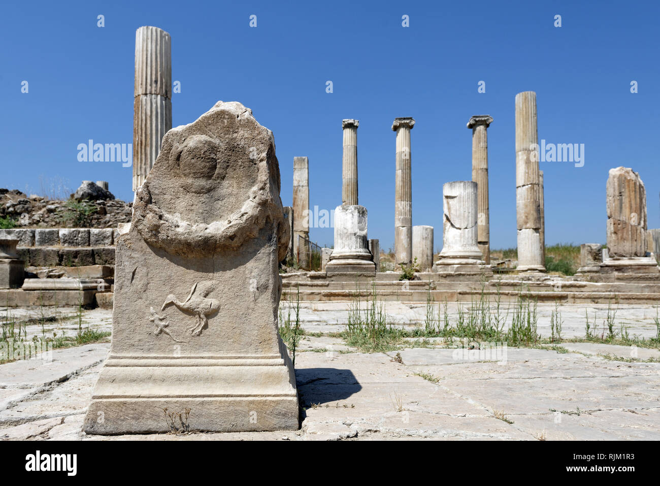 Statue pedestal with a bas relief, Agora propylon is in the background ...