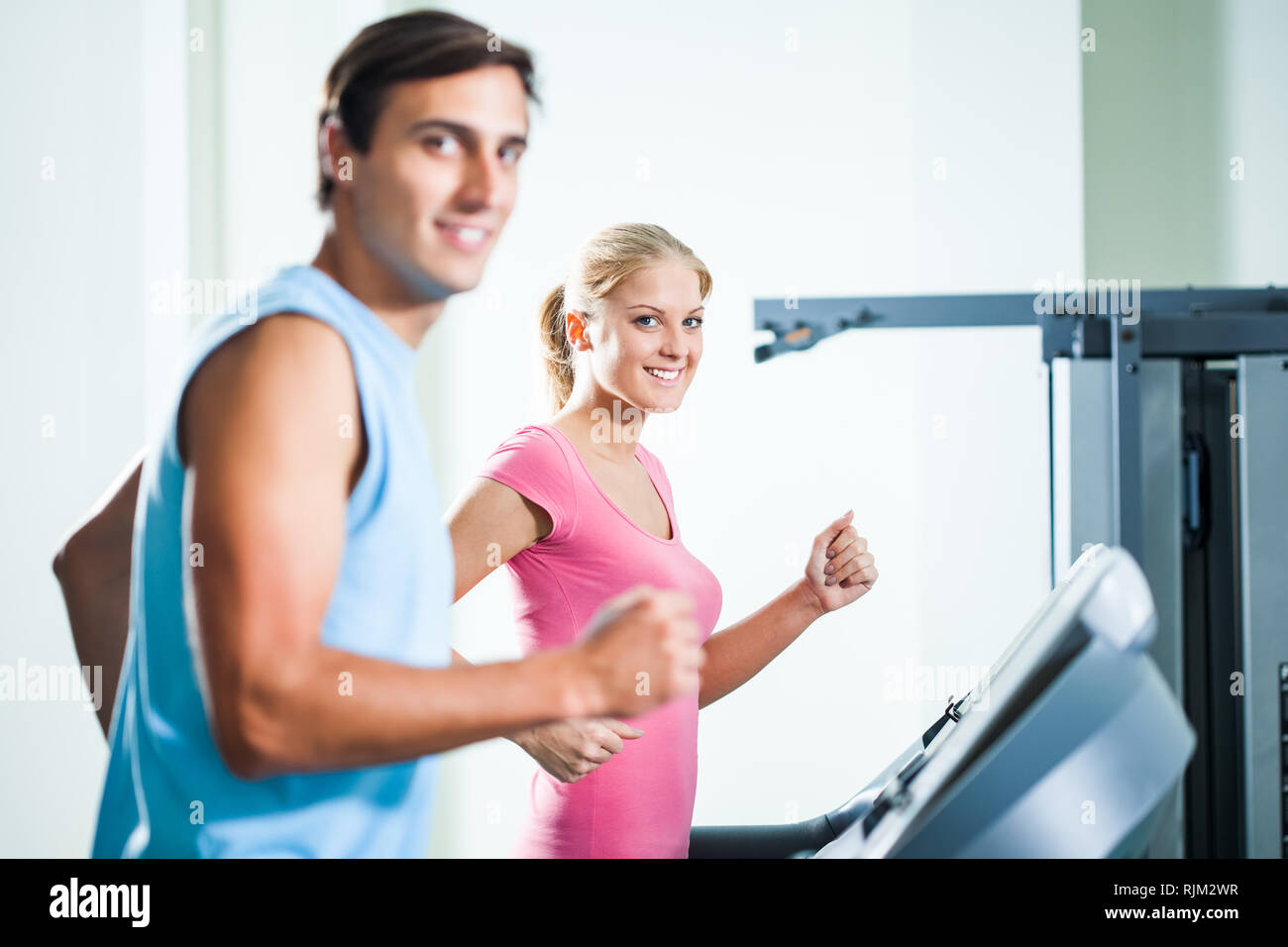 Happy couple exercising in gym Stock Photo - Alamy