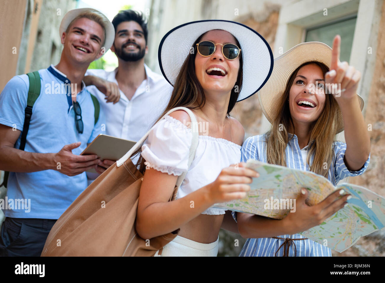 Happy group of friends tourists sightseeing in city on vacation Stock ...