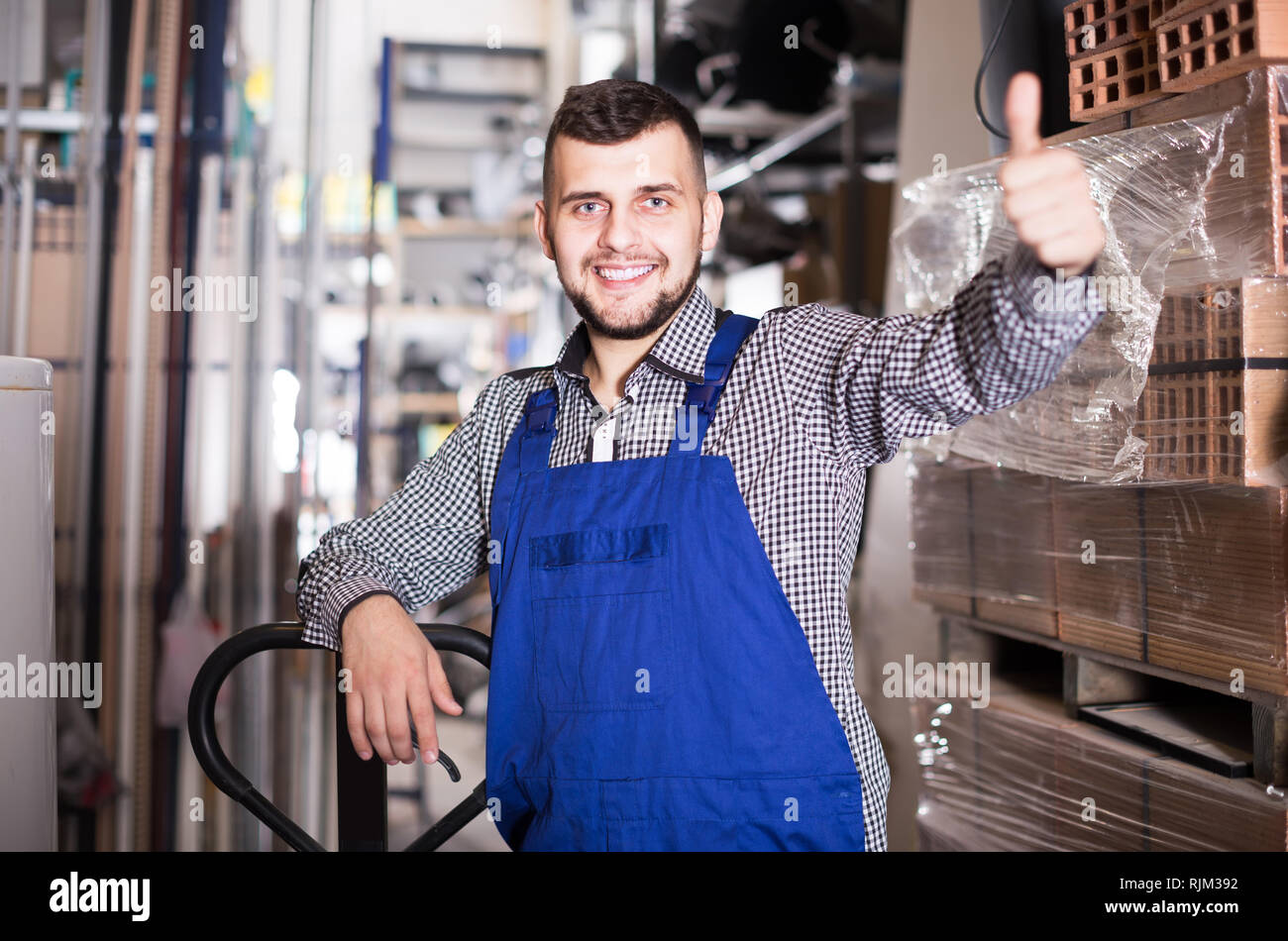 Smiling worker shows his work place in the workshop Stock Photo - Alamy