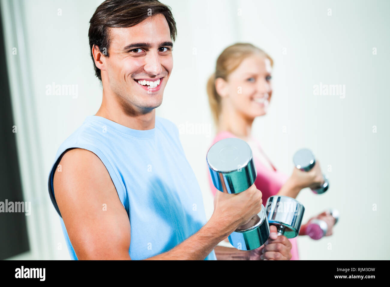 Couple exercising in gym, using weights Stock Photo - Alamy