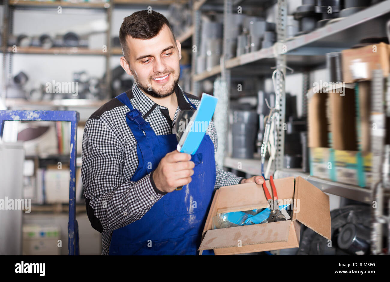 Laughing male worker showing his working tools at workshop Stock Photo ...