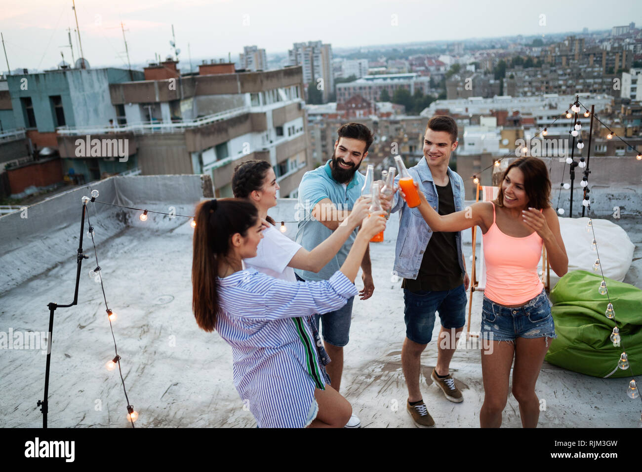 Group of happy young friends having party on rooftop Stock Photo - Alamy