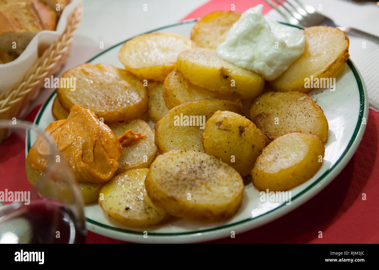 Traditional Spanish fried potatoes Patatas bravas served with cheese ...
