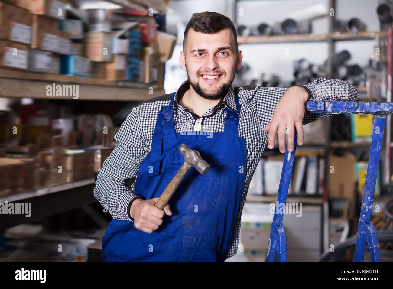 Happy male worker showing his working tools at workshop Stock Photo - Alamy