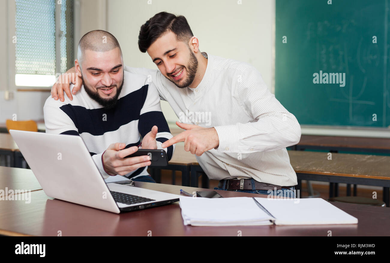 Male university students using their mobile phone instead of studying ...
