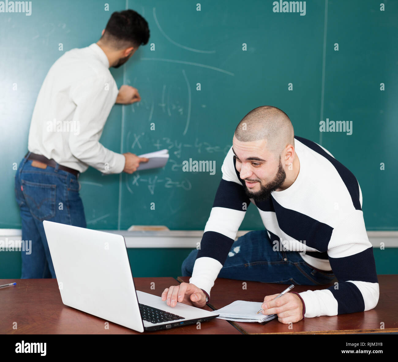 Portrait of two young guys working on their student project near ... Portrait of two young guys working on their student project near ...