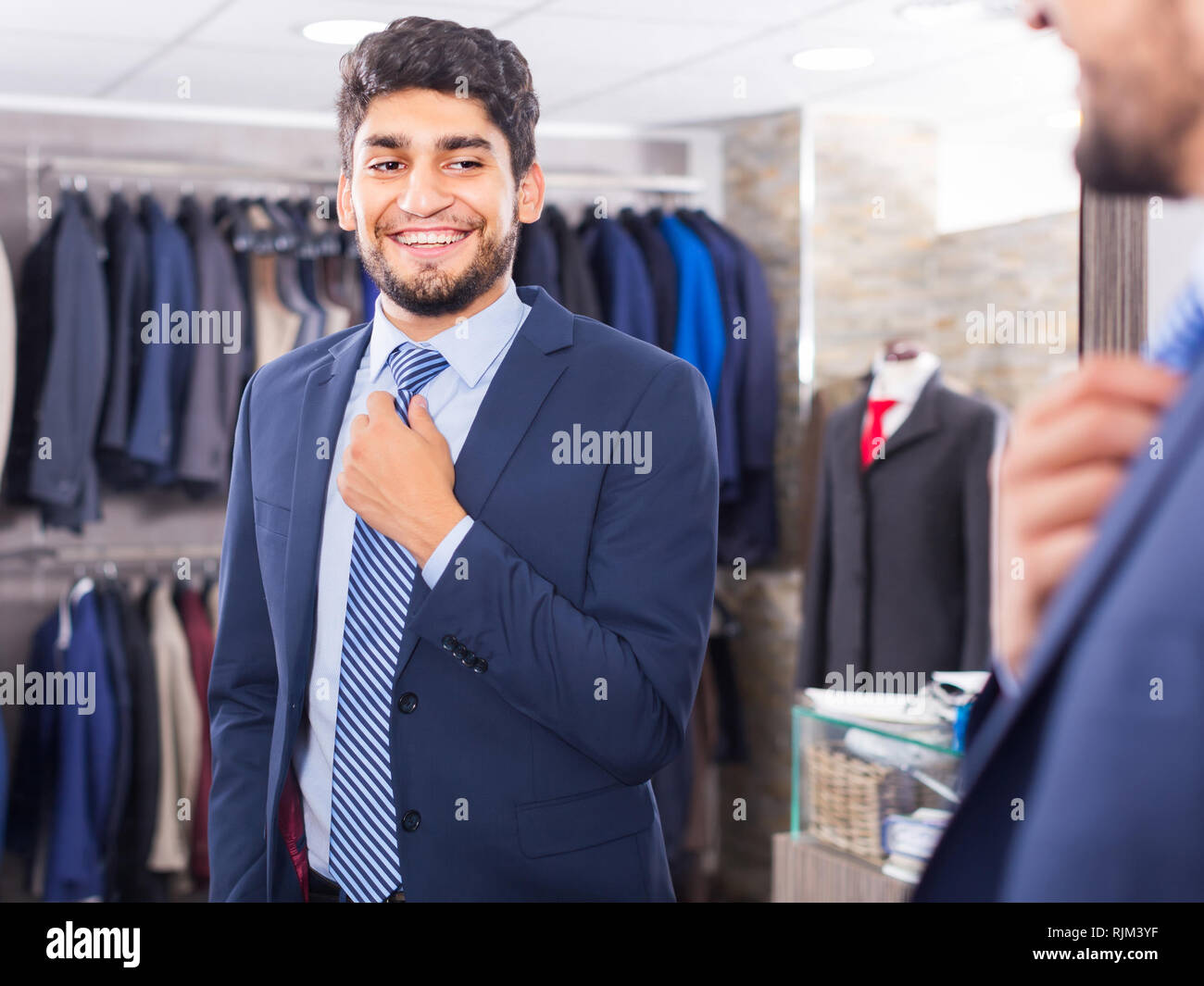 Customer is trying on tie in front of the mirror in men's shop Stock ...