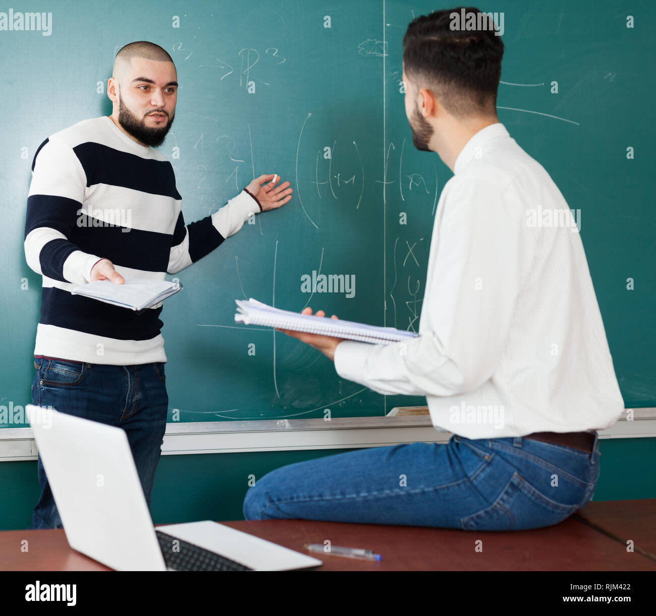 Two male university students preparing for exams together at classroom ...