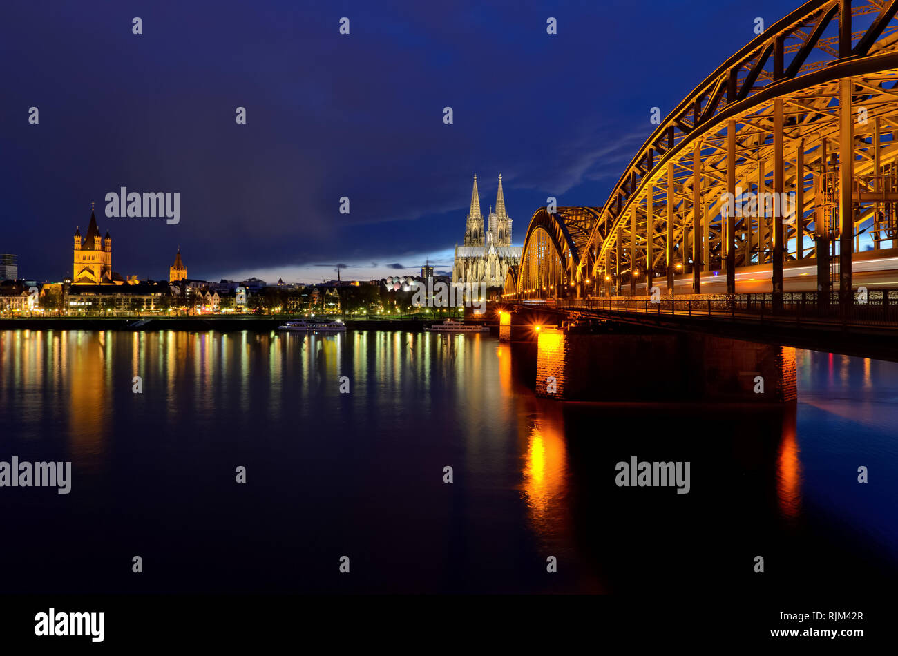 Hohenzollern bridge and Cathedral illuminated at dusk, Cologne, Germany ...
