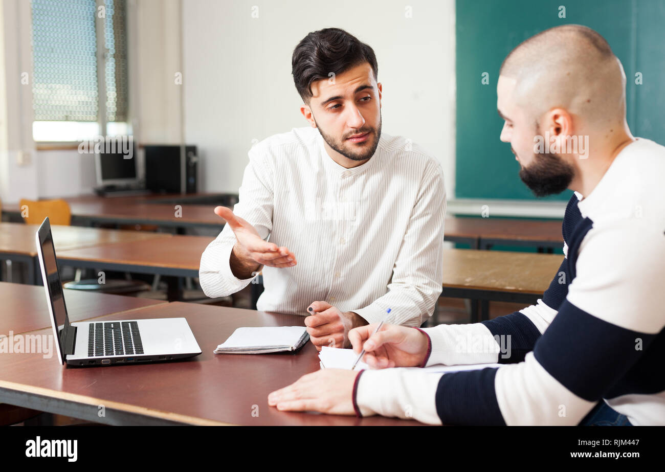 Two male university students sitting at desk preparing for exams ...