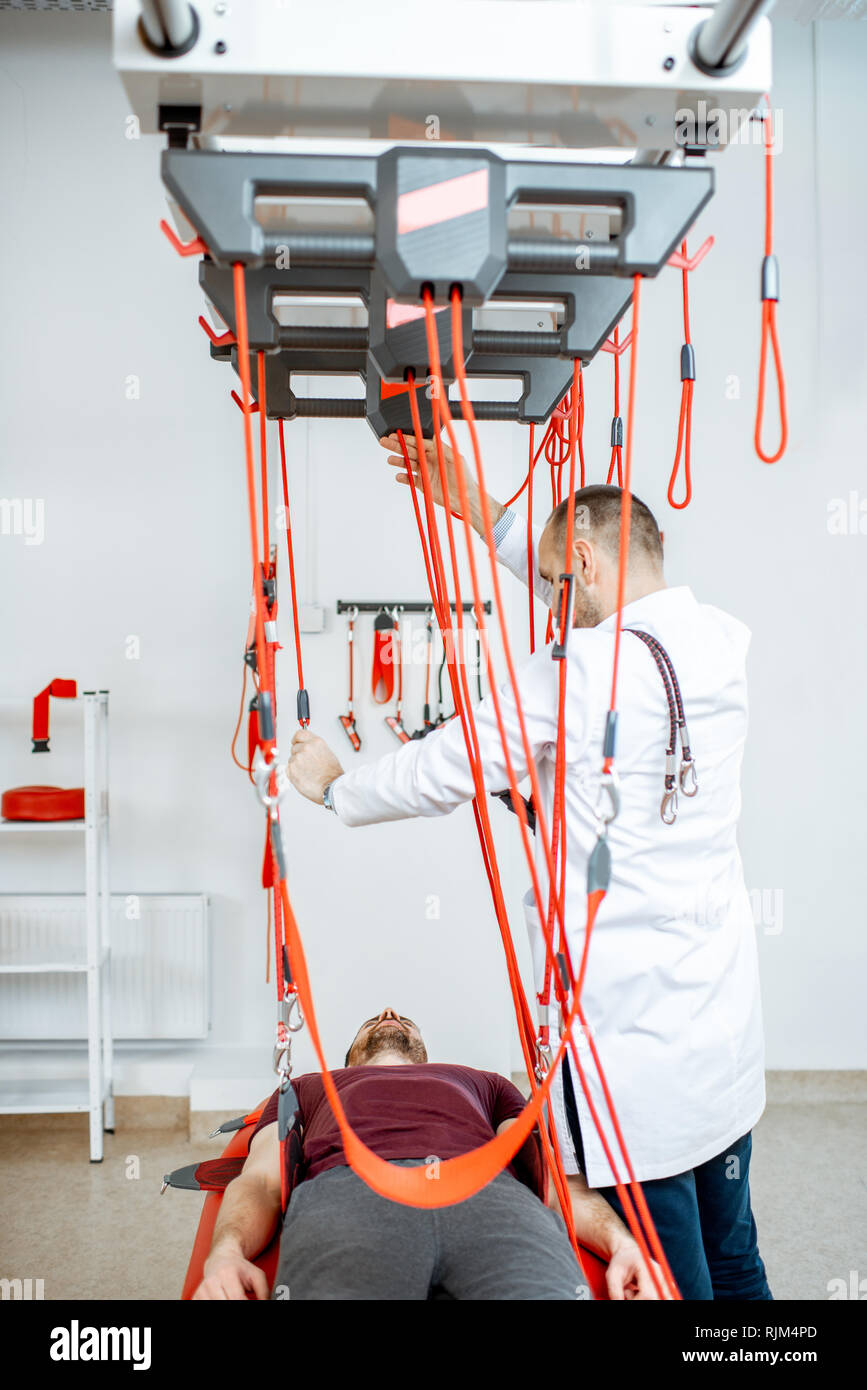 Senior physiotherapist doing treatment to a man with spine problems ...