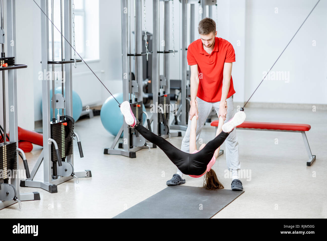 Young girl exercising on the decompression simulators with trainer ...