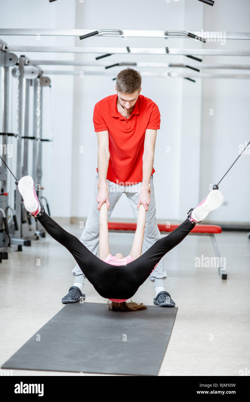 Young girl exercising on the decompression simulators with trainer ...