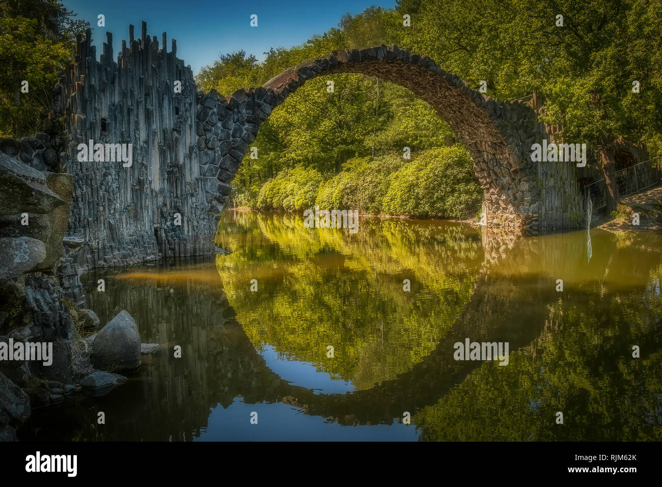 Old arch bridge at the lake with reflections in the water Stock Photo ...