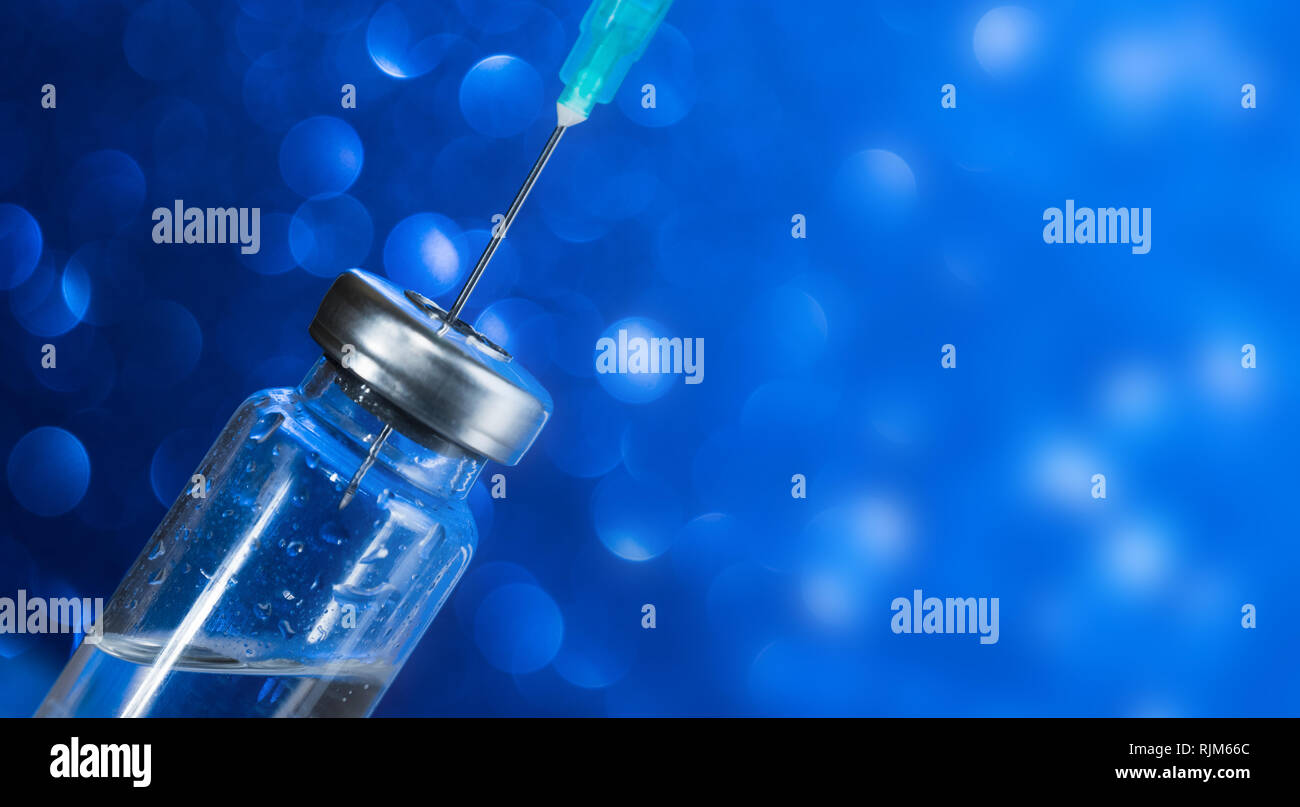Injection vial with syringe needle on blue background Stock Photo - Alamy