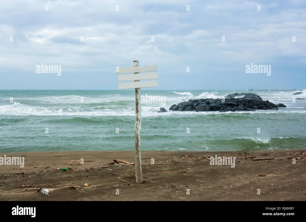 A blank sign in front of the sea on Fiumicino (Rome) sea. Sea waves ...