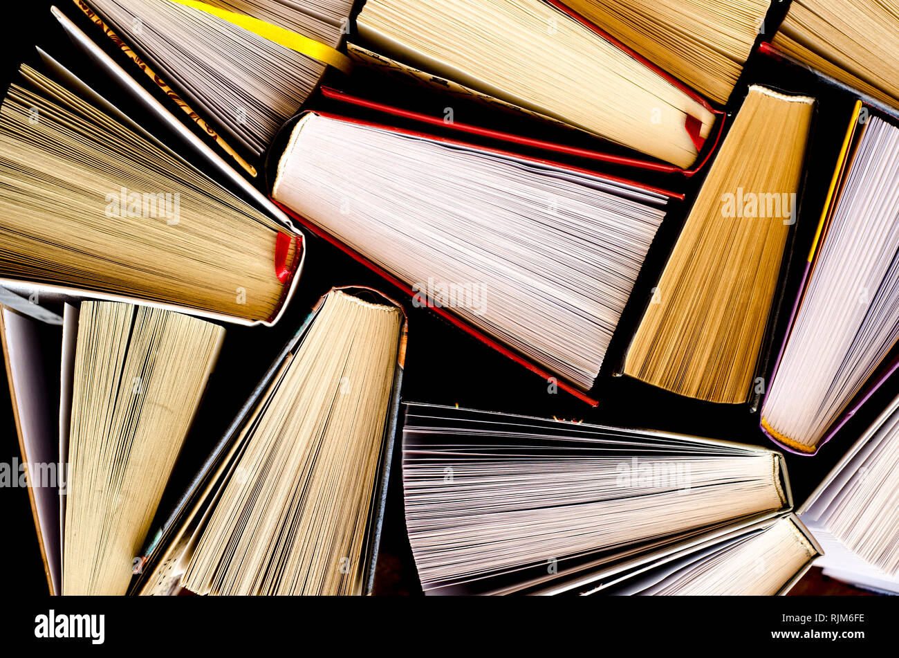 Lots of colourful thick open books stand on a dark background Stock ...