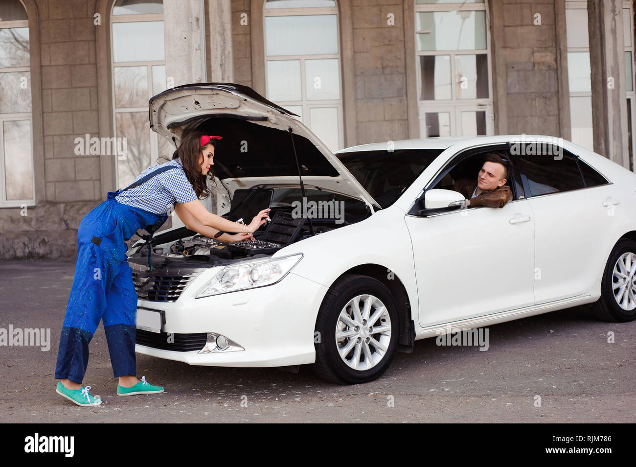 Cute attractive girl examining car engine at the auto repair sho Stock ...