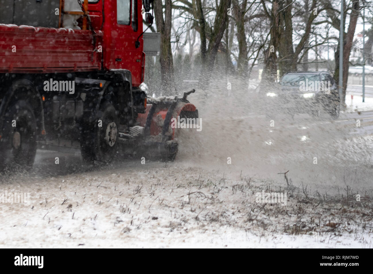 Snow plow removing snow dissolving from the roadway and sprinkling salt ...