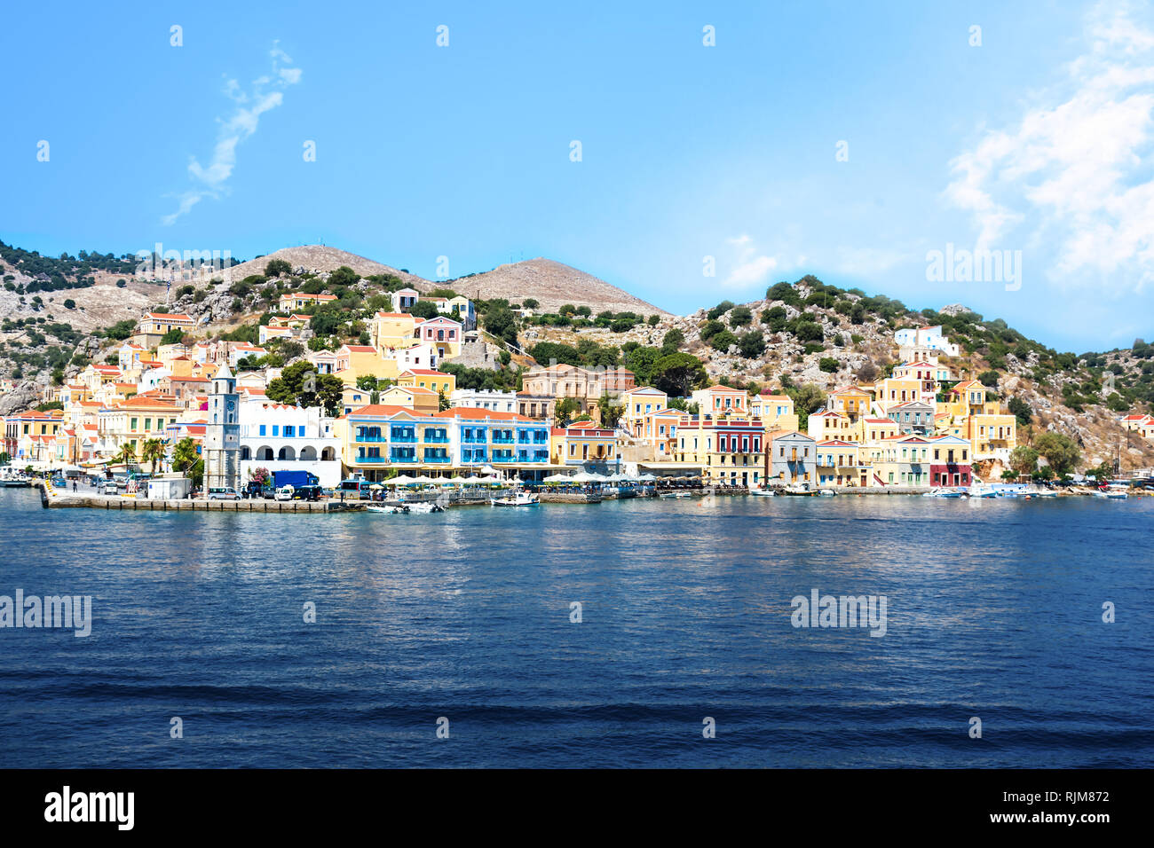 Bell-tower and colorful neoclassical houses in harbor town of Symi ...