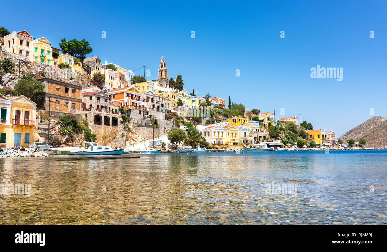 Anchored boats and colorful neoclassical houses in bay of Symi (Symi ...