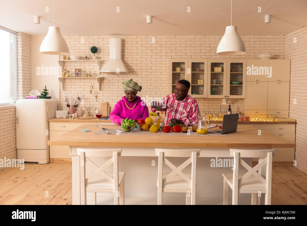 Delighted positive couple cooking food in the kitchen Stock Photo - Alamy