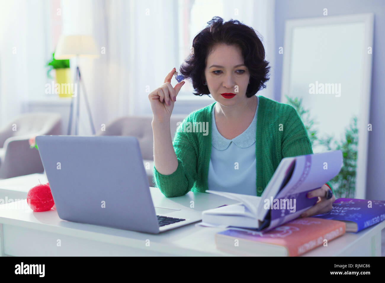 Smart good looking woman reading a special book Stock Photo - Alamy