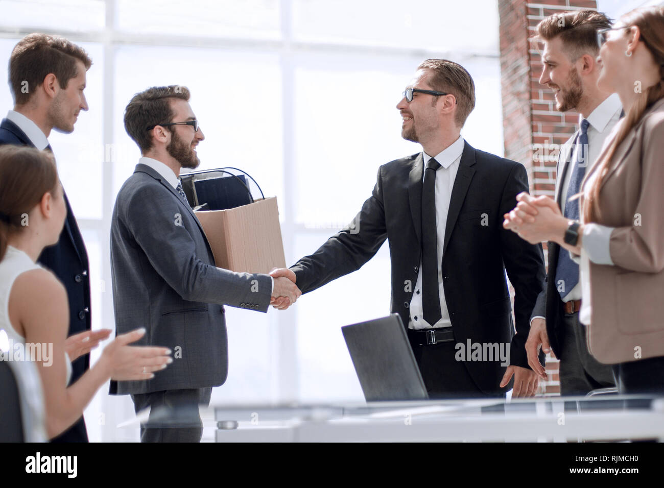 Manager shaking hands with new employee Stock Photo - Alamy