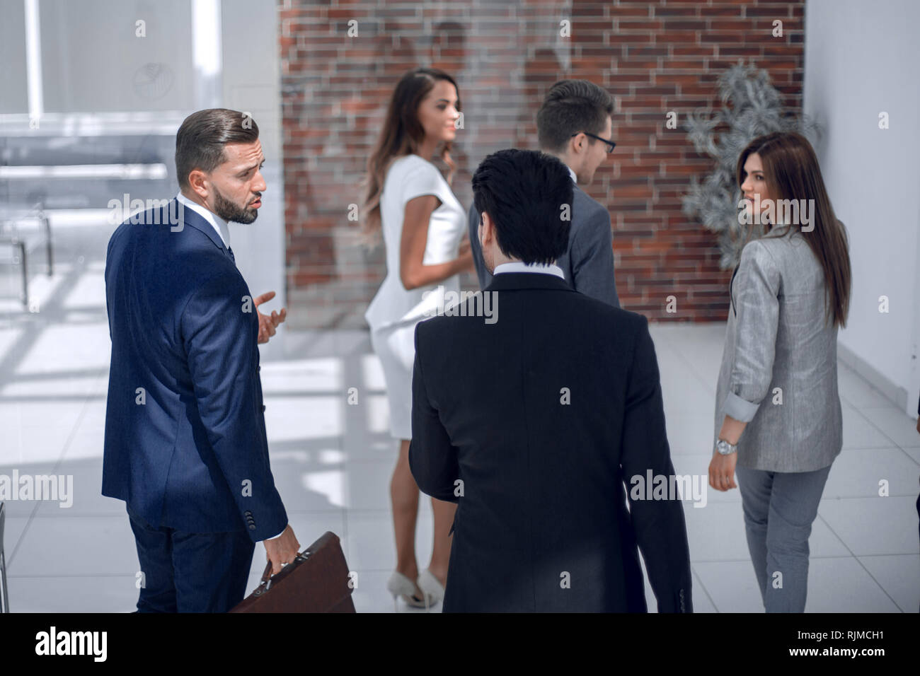 employees standing in the hall of a modern office Stock Photo - Alamy