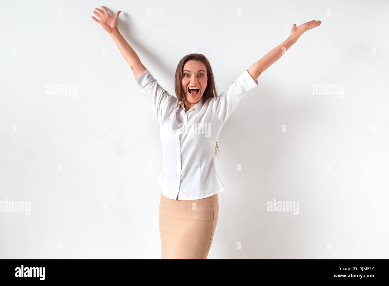 Success achieved. Woman standing isolated on white hands up shouting ...