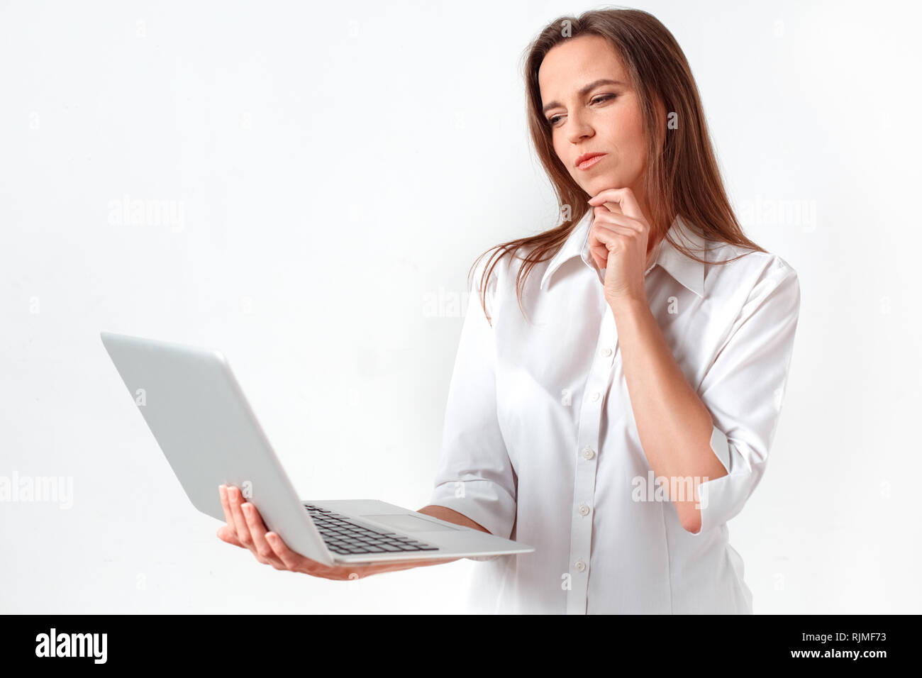 Freelance. Woman standing isolated on white with laptop looking at ...