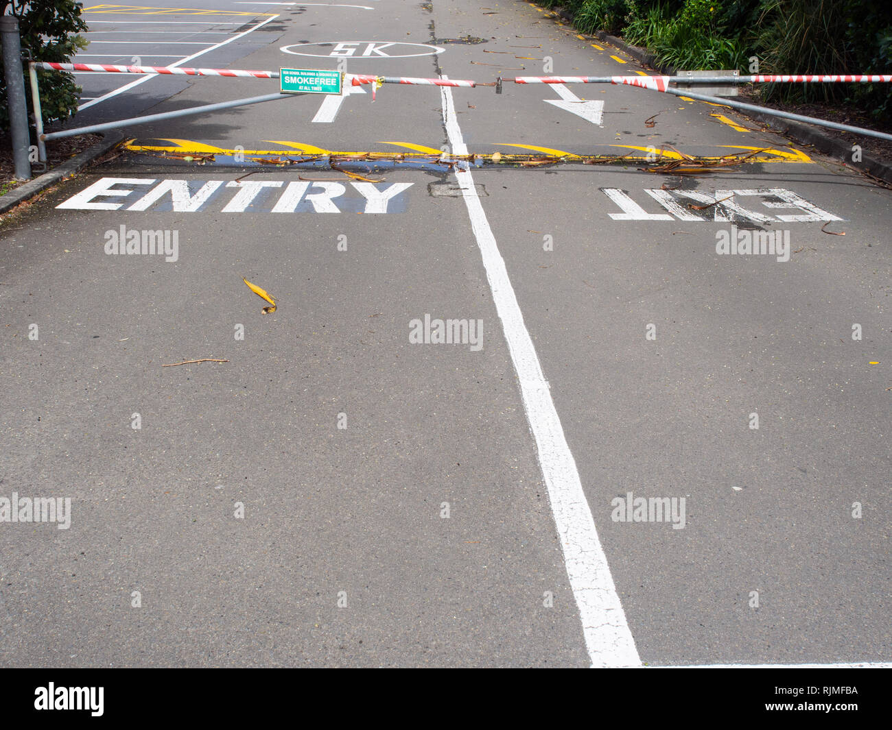 White Entry and Exit road markings painted on asphalt at a car park ...