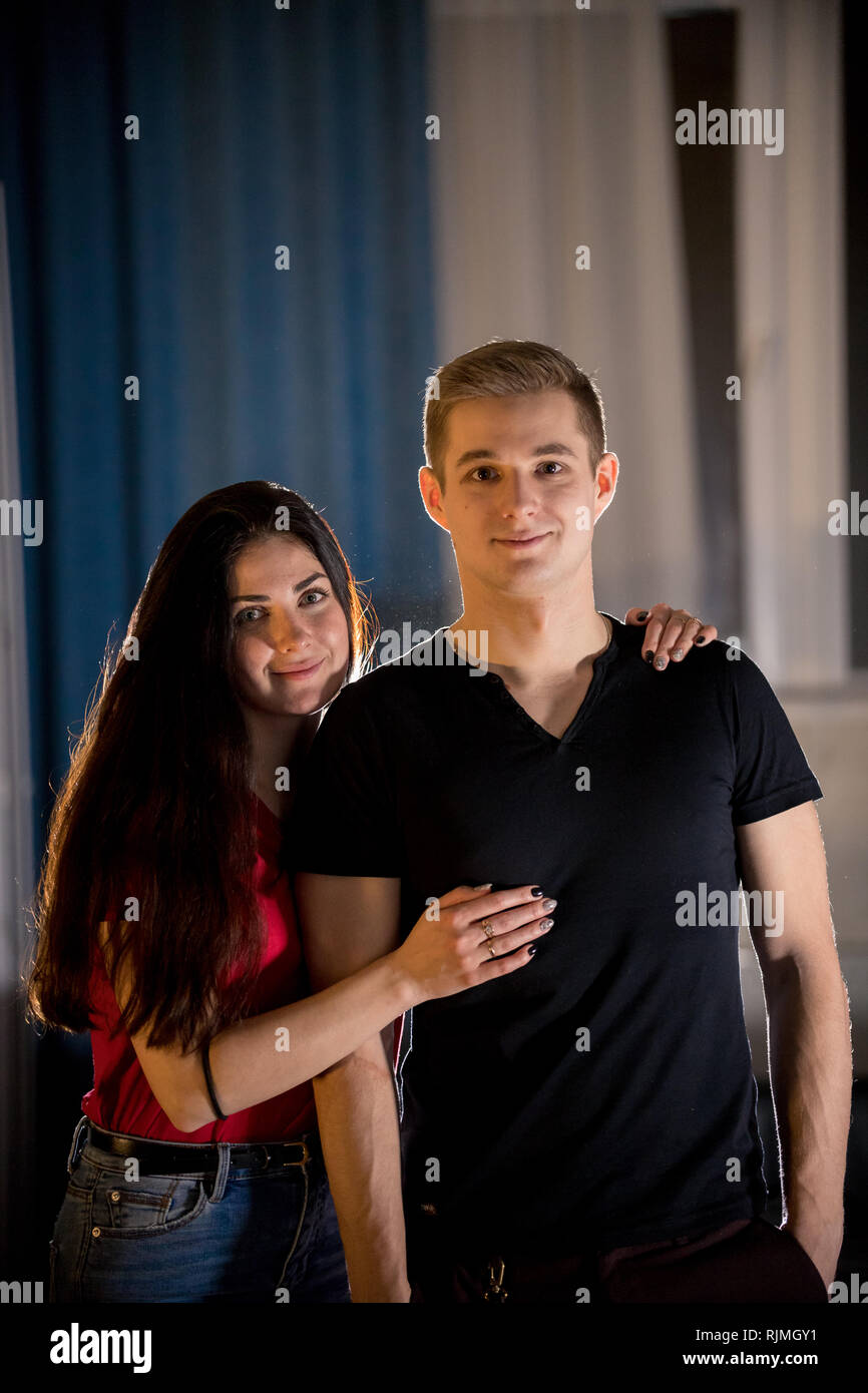 Young smiling couple. A young woman hugging her boyfriend from the back Stock Photo - Alamy