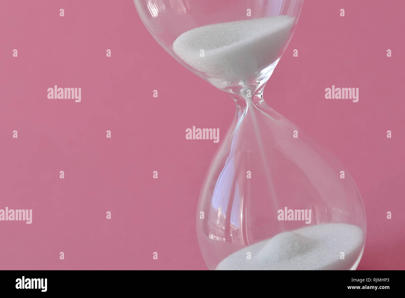 Hourglass on pink background - Concept of health, fertility and ...