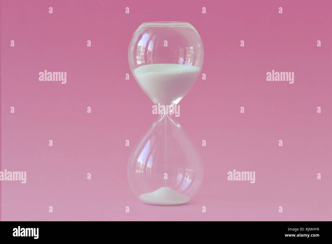 Hourglass on pink background - Concept of health, fertility and ...