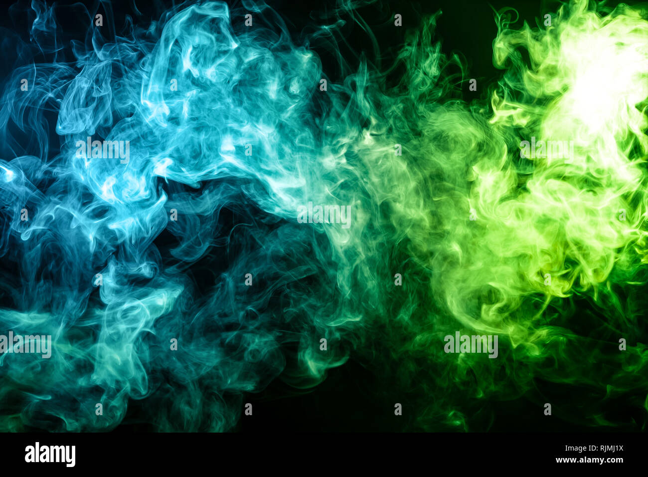 Blue and green bomb smoke on black isolated background Stock Photo - Alamy