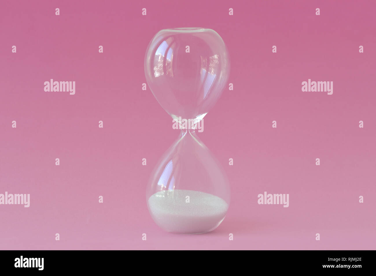 Hourglass on pink background - Concept of infertility and biological ...