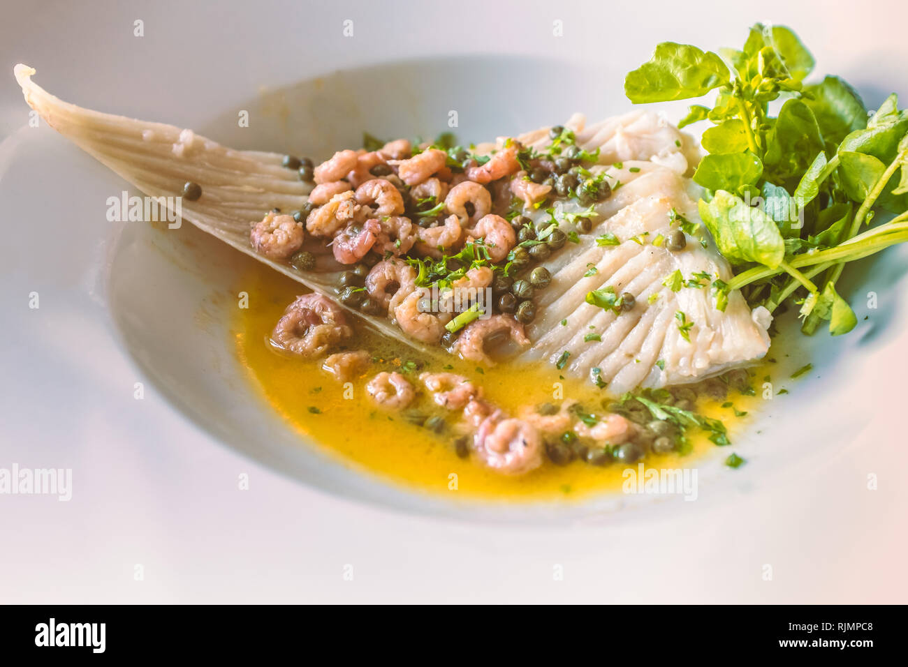Skate wing served with capers and shrimps plus green salad and a butter ...