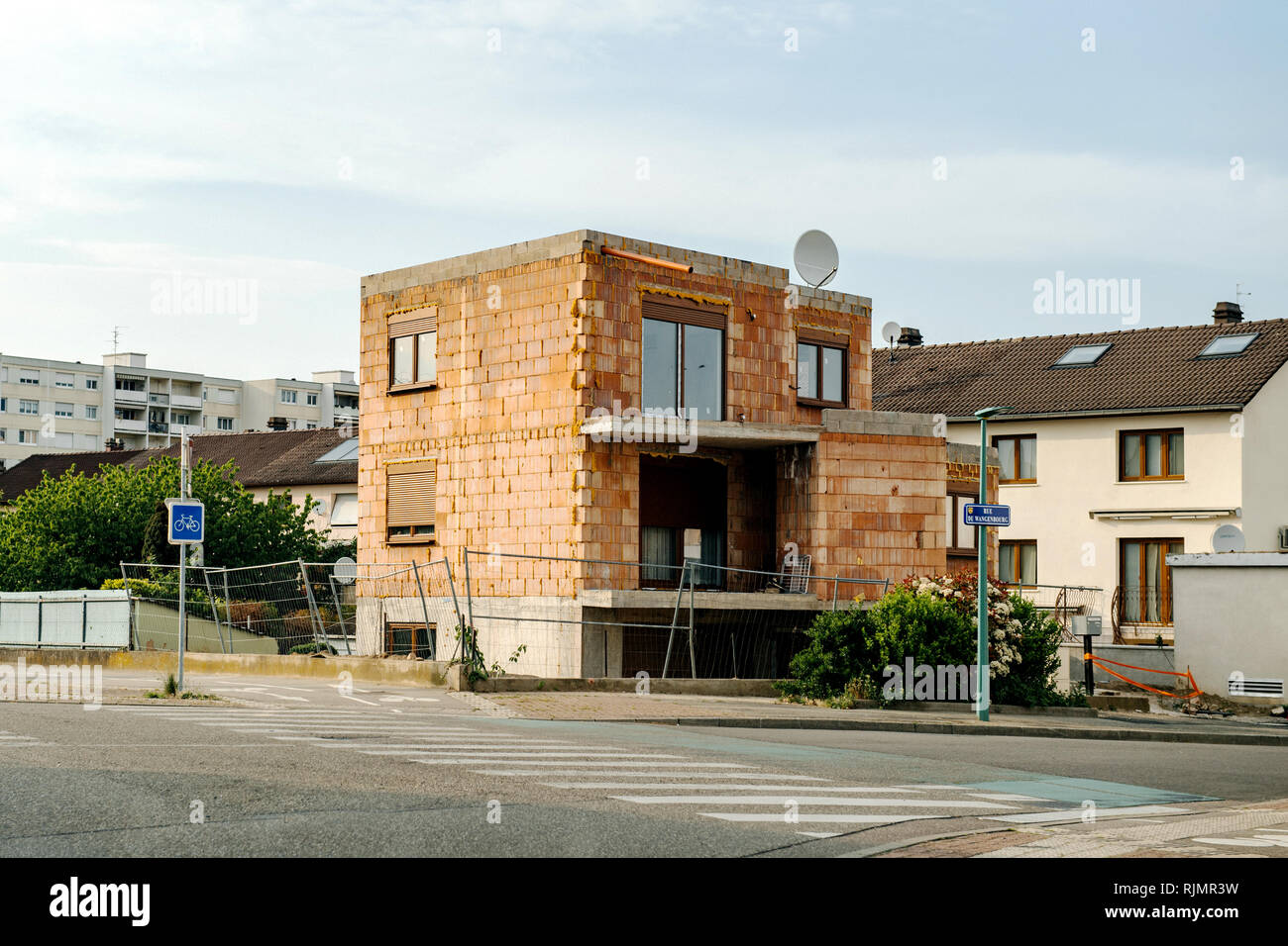 Empty calm street with small unfinished brick house and crosswalk near ...