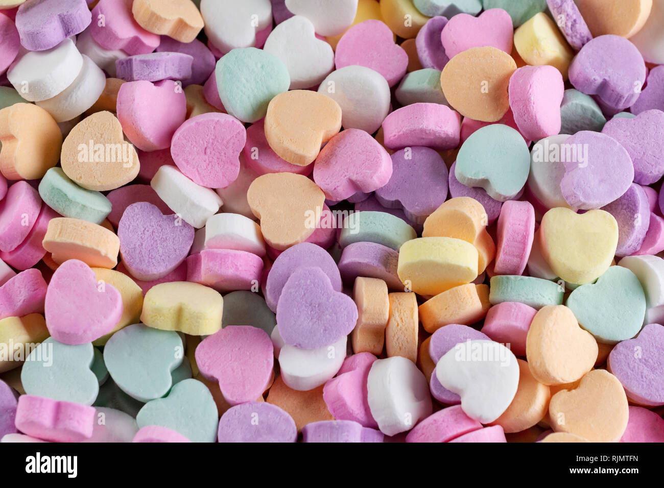 An assortment of conversation hearts taken from top down view. Pastel ...