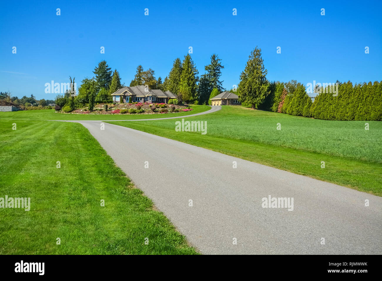 Road going through rural landscape with farmer's house on the hill ...