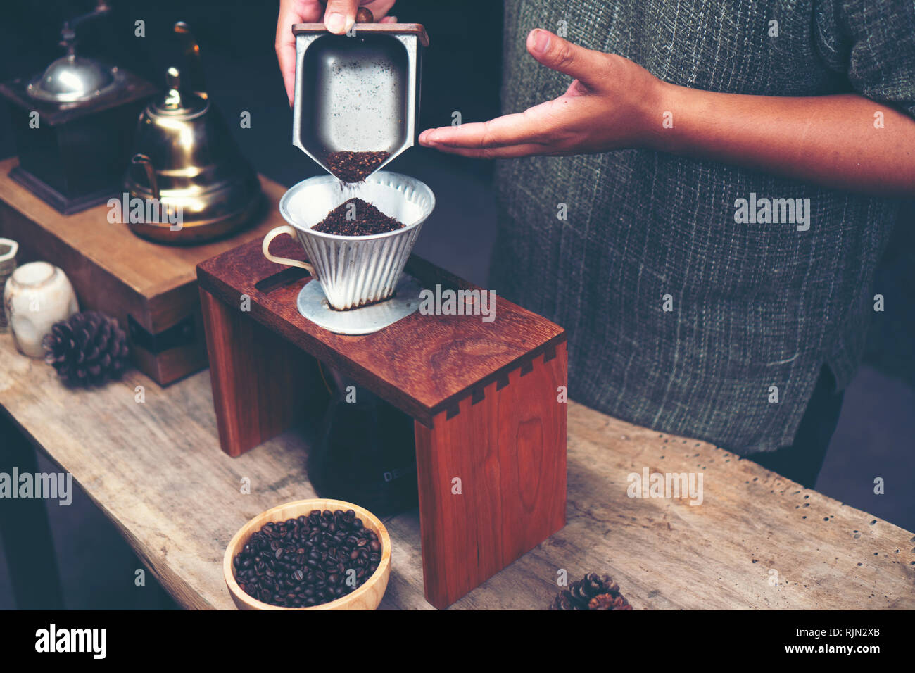 Barista is grinding coffee with a hand coffee grinder Stock Photo - Alamy