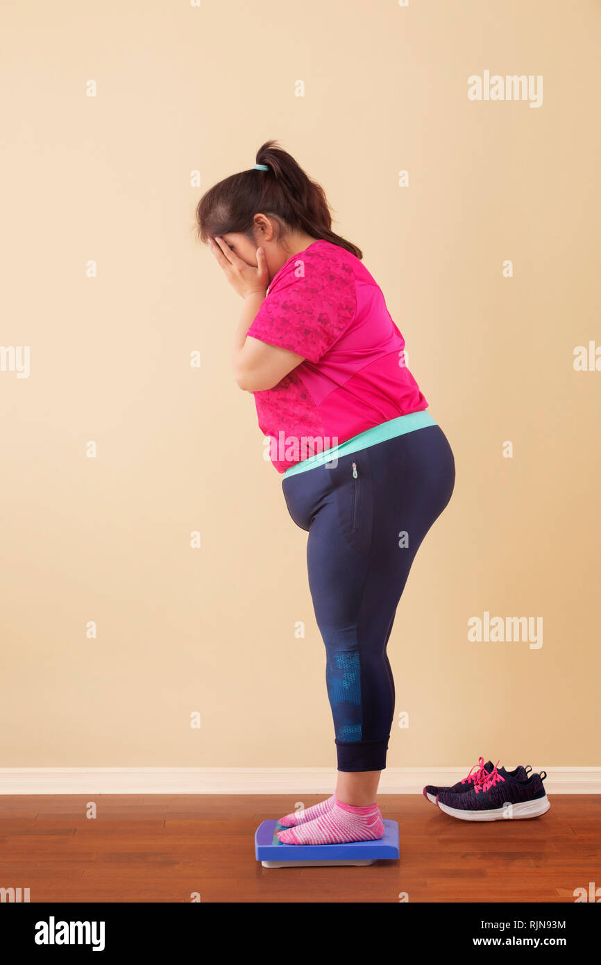Shocked Overweight Woman Standing On Measuring Scale Stock Photo - Alamy