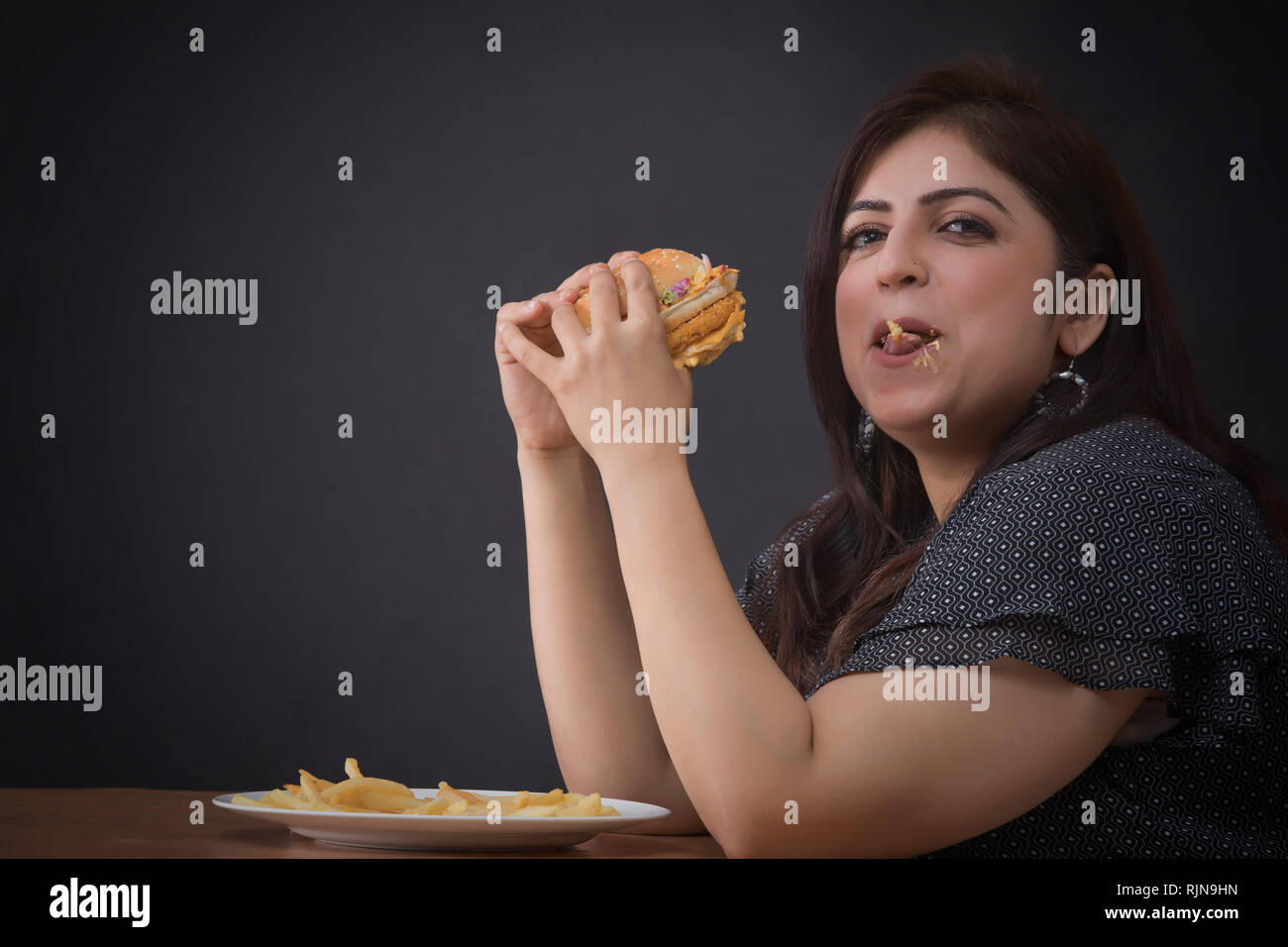 Fat woman eating a hamburger Stock Photo - Alamy