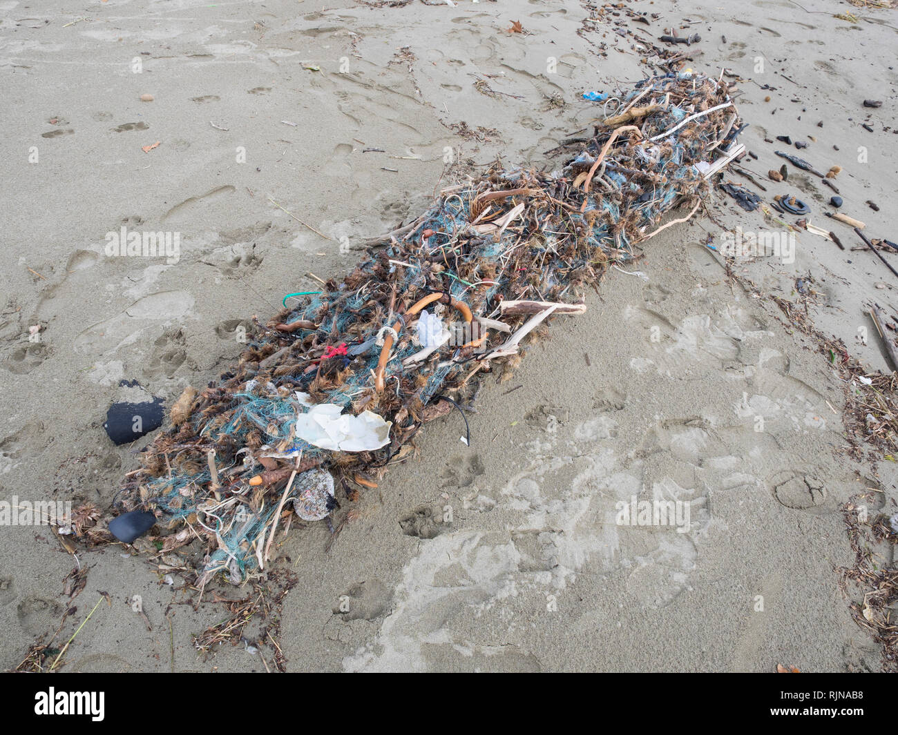 fishing net arrived on the beach full of plastic waste. Symbol fo ocean ...